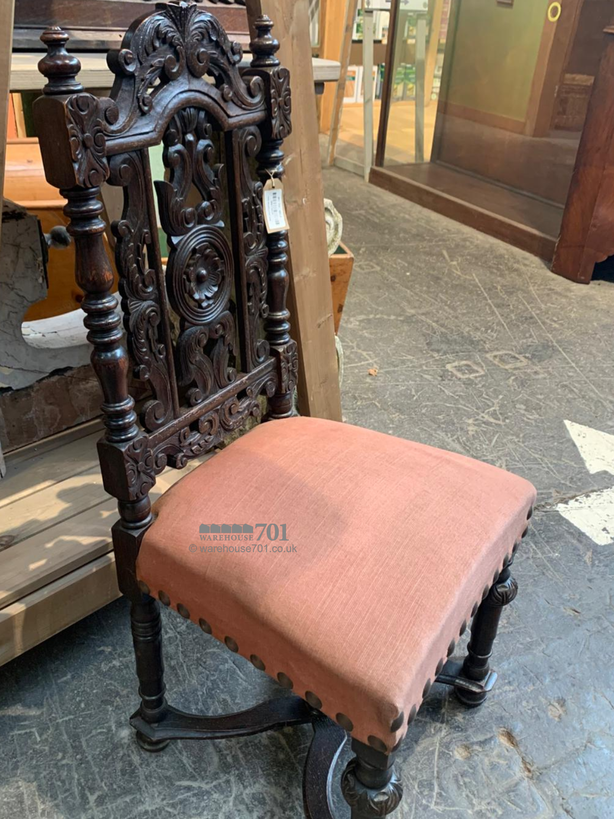 Dark wood relief carving chair with padded seat